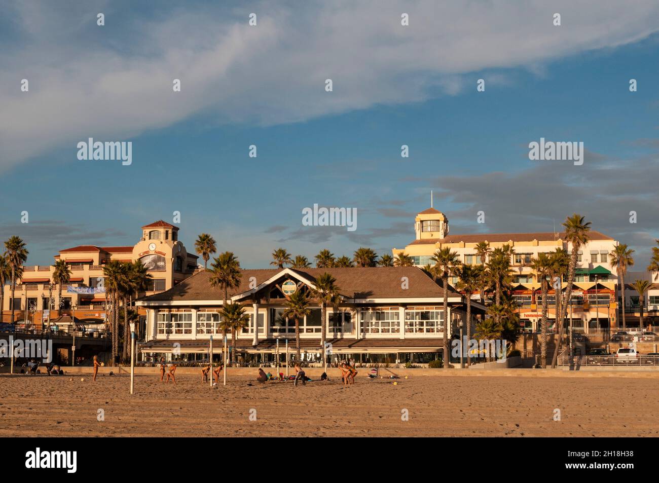 Volleyball players on Huntington Beach fronting sunlit waterfront ...