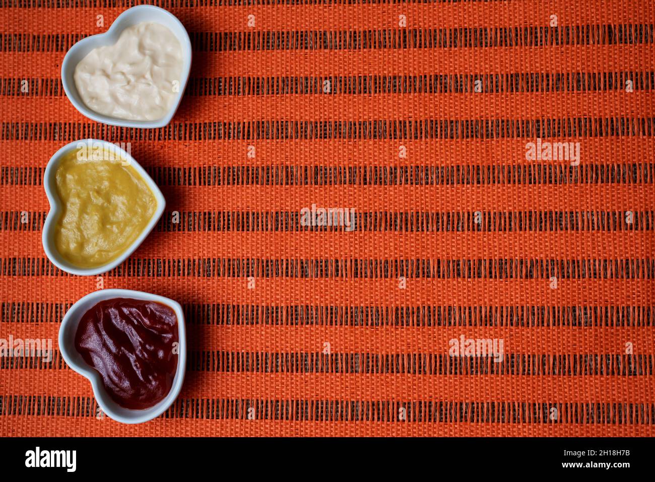 Small heart shaped bowls with ketchup, mayonnaise and mustard sauce ...
