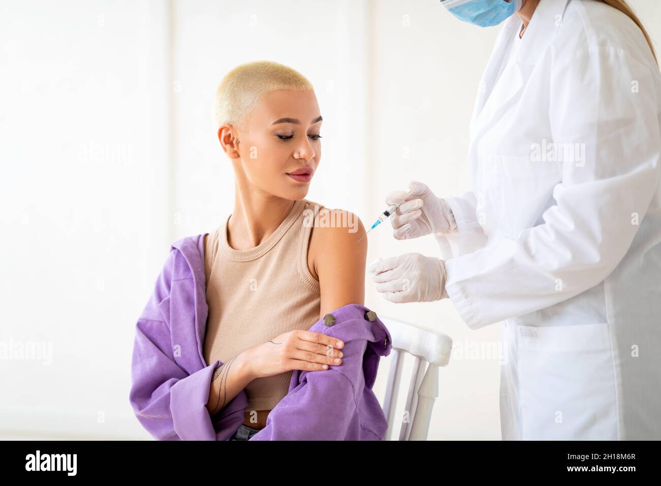 Medical doctor or nurse giving coronavirus vaccine shot to young woman ...