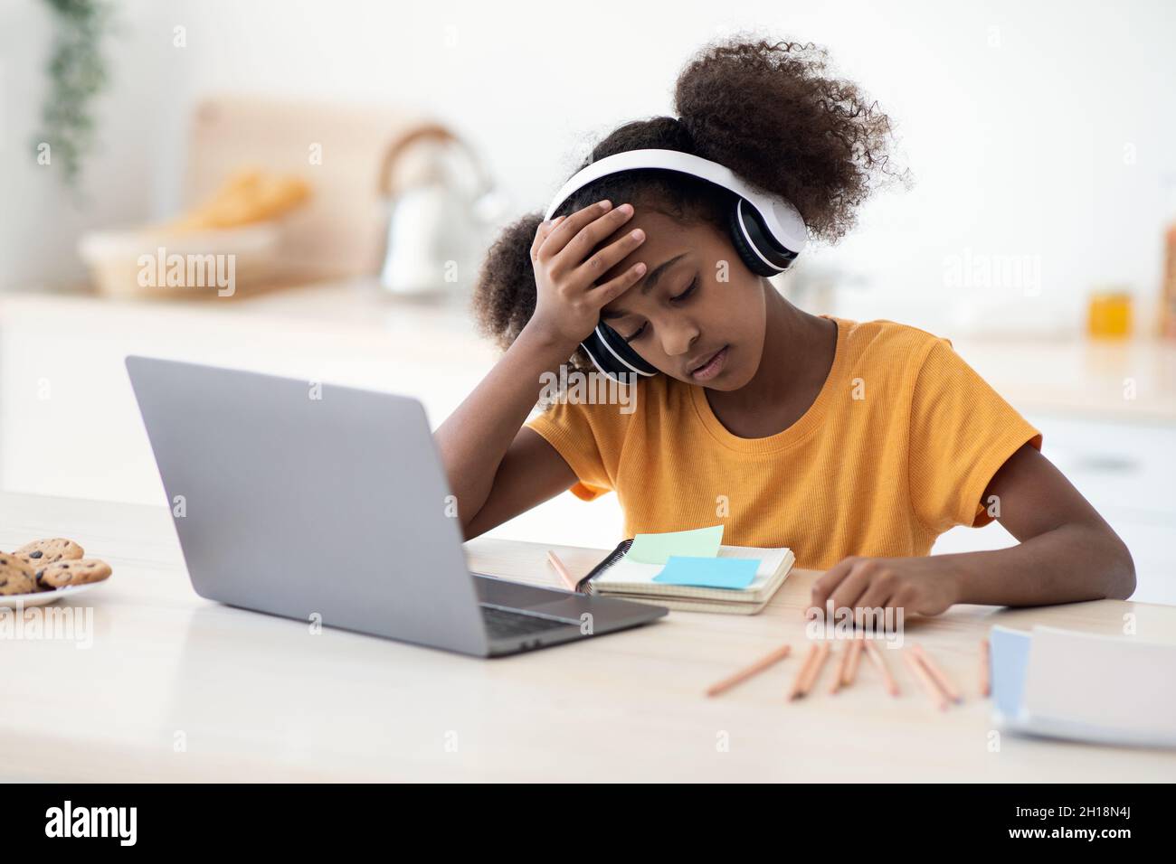 Upset black school girl doing homework, kitchen interior Stock Photo ...