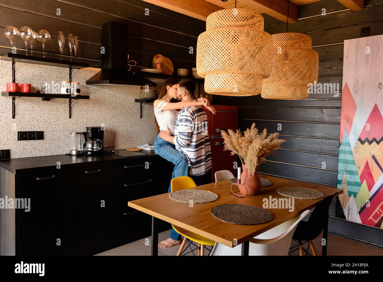 Intimate intimacy of two lovers in the kitchen, a girl sitting at the ...
