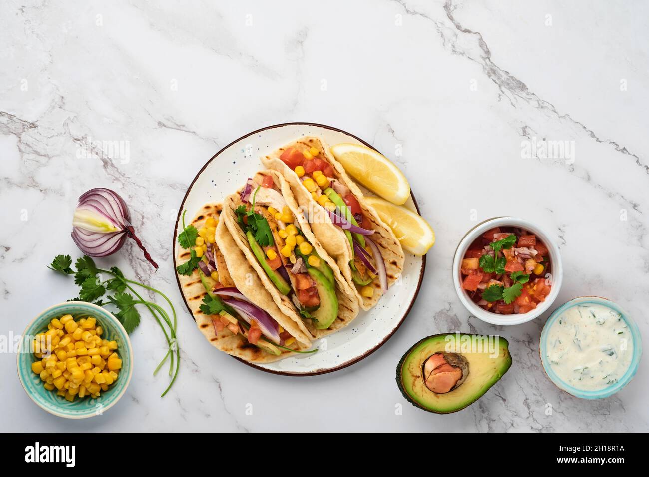 Mexican tacos with grilled chicken, avocado, corn kernels, tomato ...