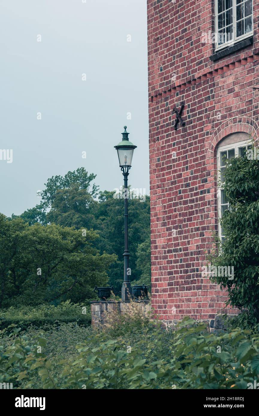 Historic brick building with old lamp post in park environment Stock ...