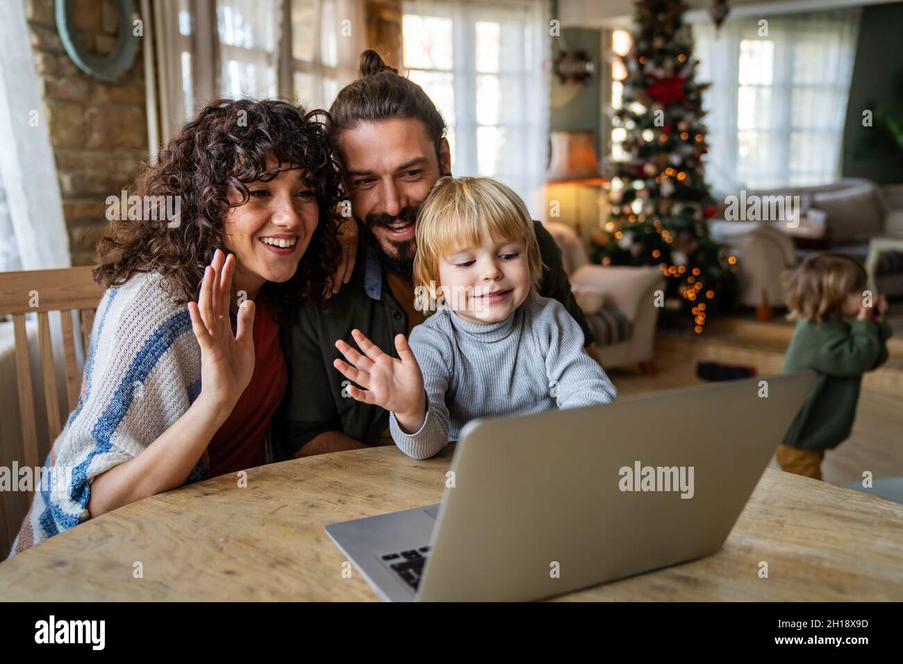 Happy family with kid having fun using laptop together, watching ...