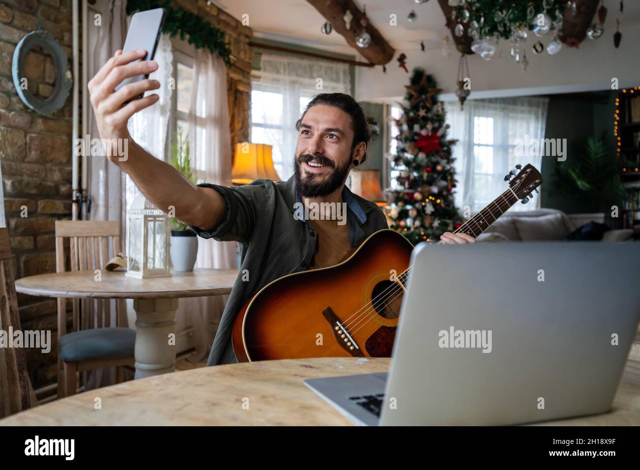 Portrait of a man taking guitar lessons online in a room at home Stock ...