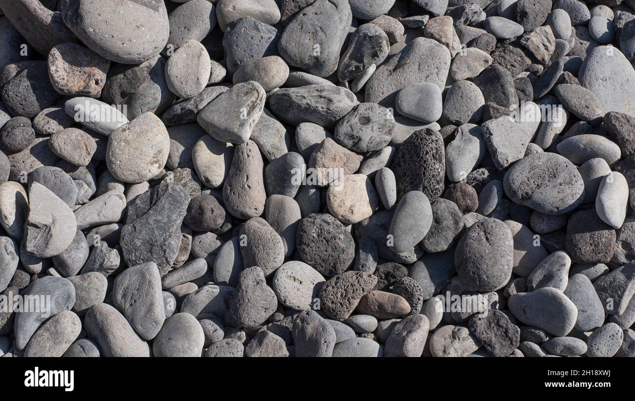 Close-up grey leveled pebble beach background with copy space ...