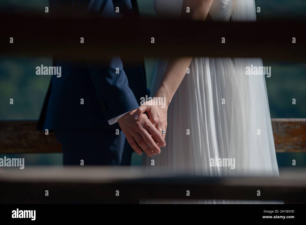 young Caucasian bride wearing a silky white dress and groom in a dark ...