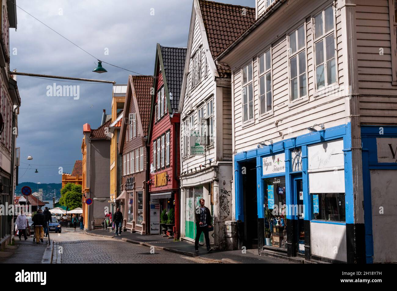 Pedestrians walk past brightly painted shops on Kong Oscars Gate, one ...