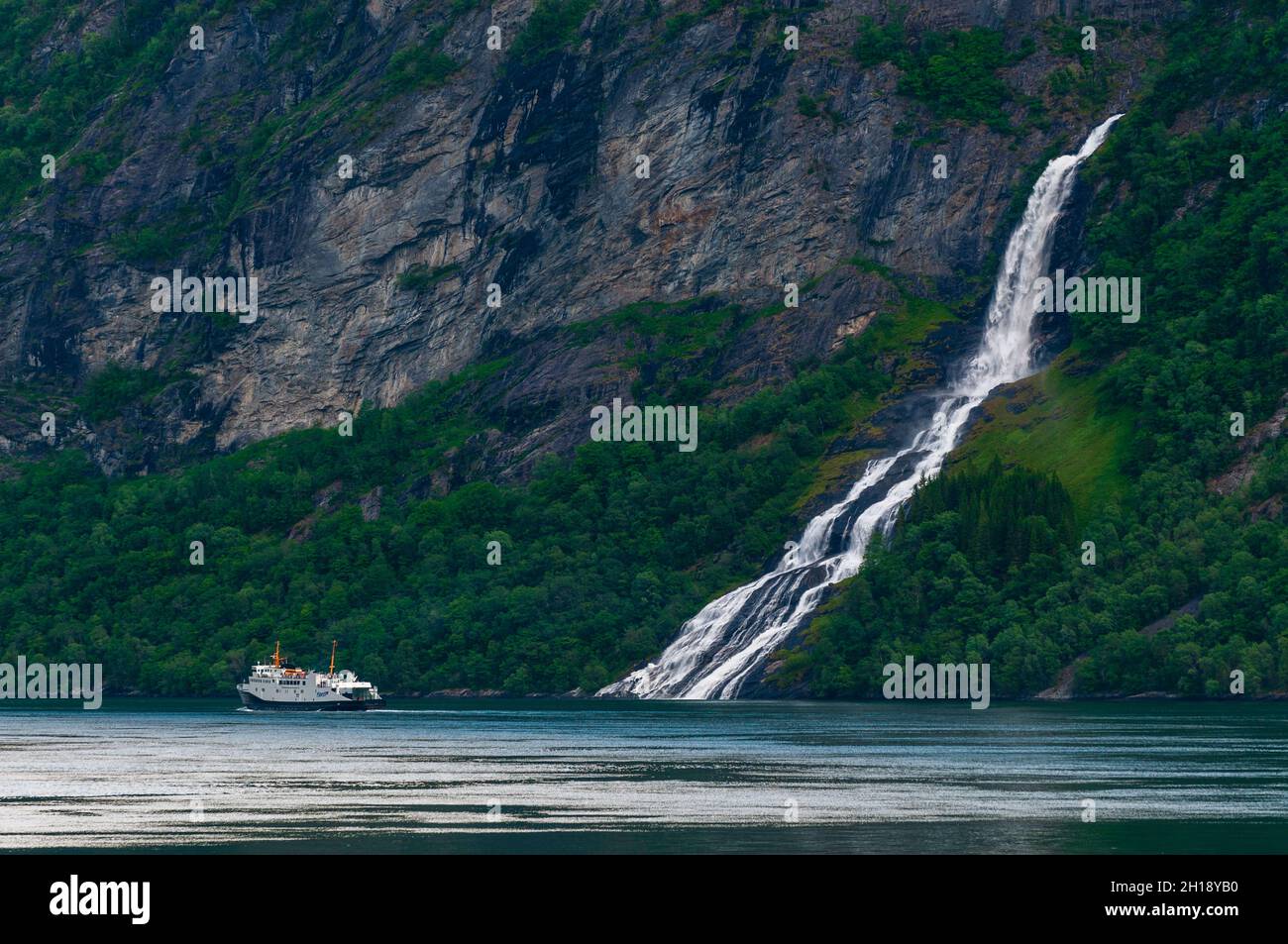 A cruise ship in near waterfalls in Geirangerfjord. Geirangerfjord ...