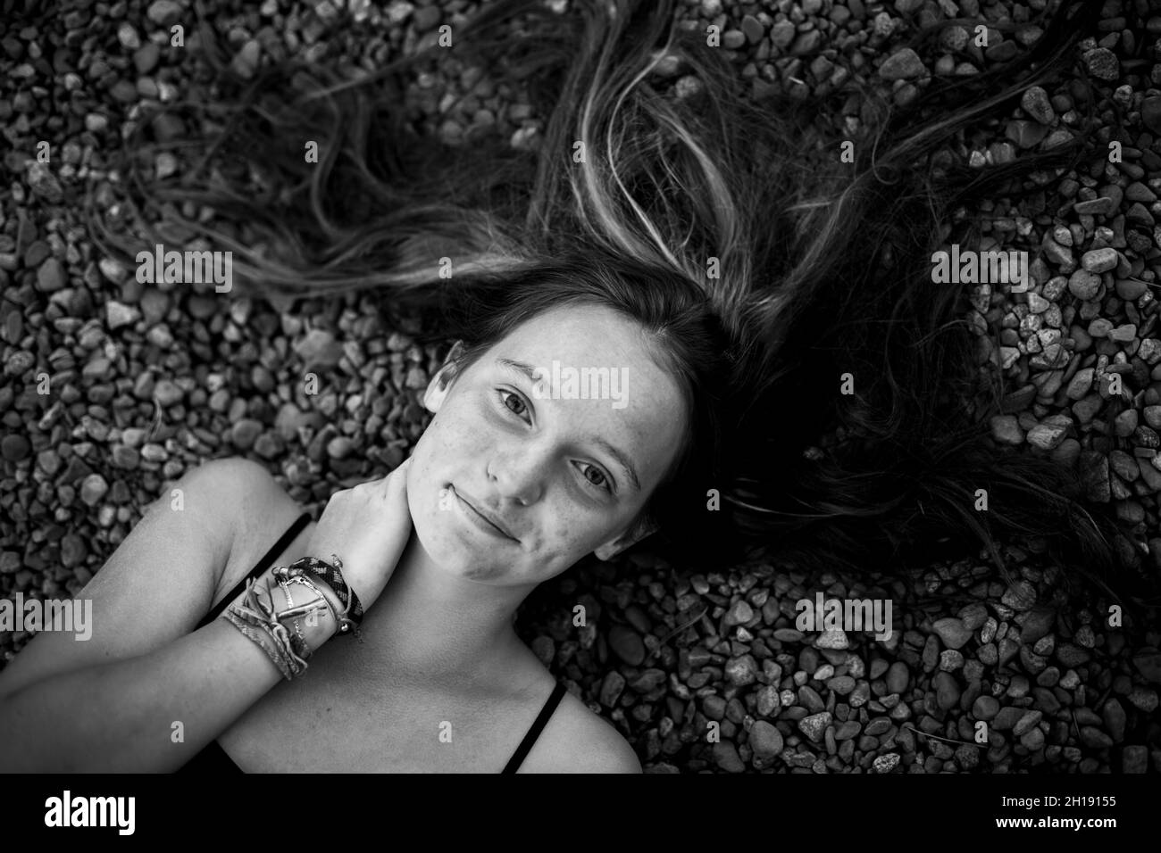 A teen girl is lying, a picture from above close-up. Black and white ...