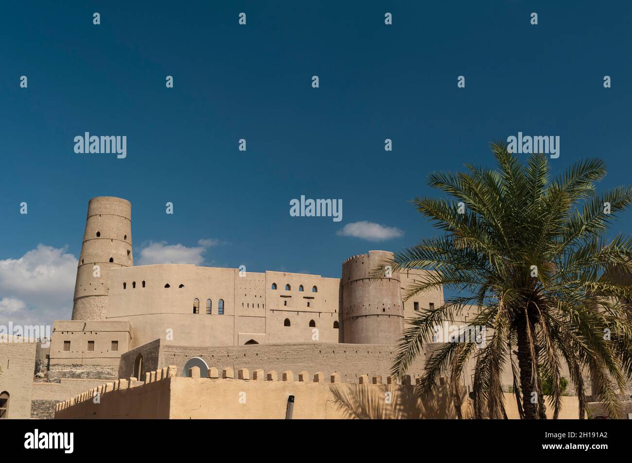 The Bahla fort, built in 13th century, and a palm tree. Bahla, Oman ...