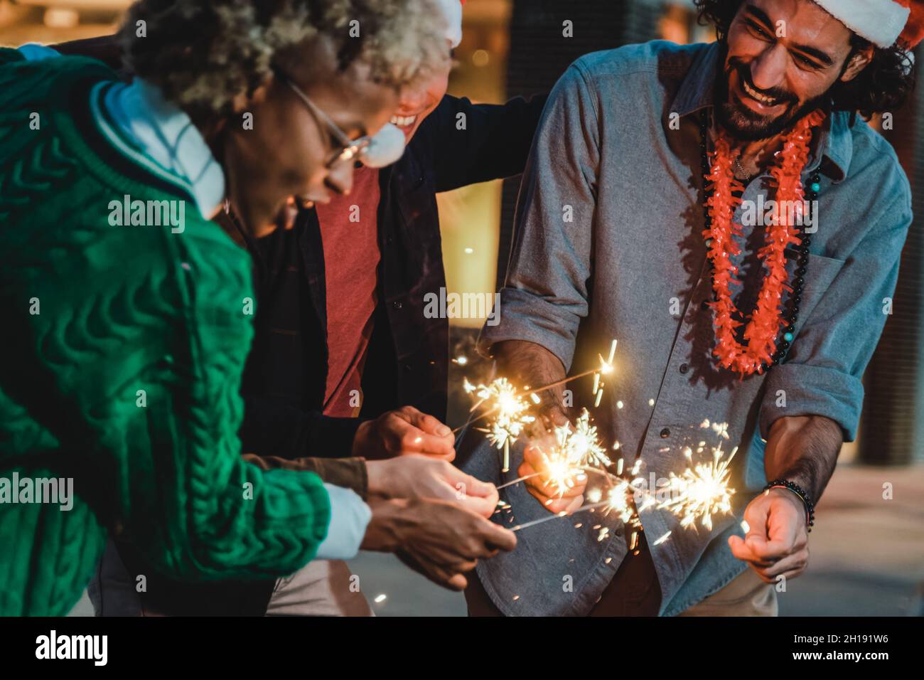 Happy diverse friends celebrating with sparklers on new year eve - Soft ...