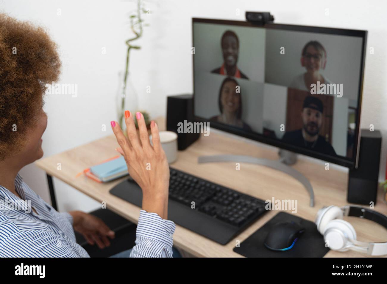 African woman doing video call meeting with co-workers from home ...