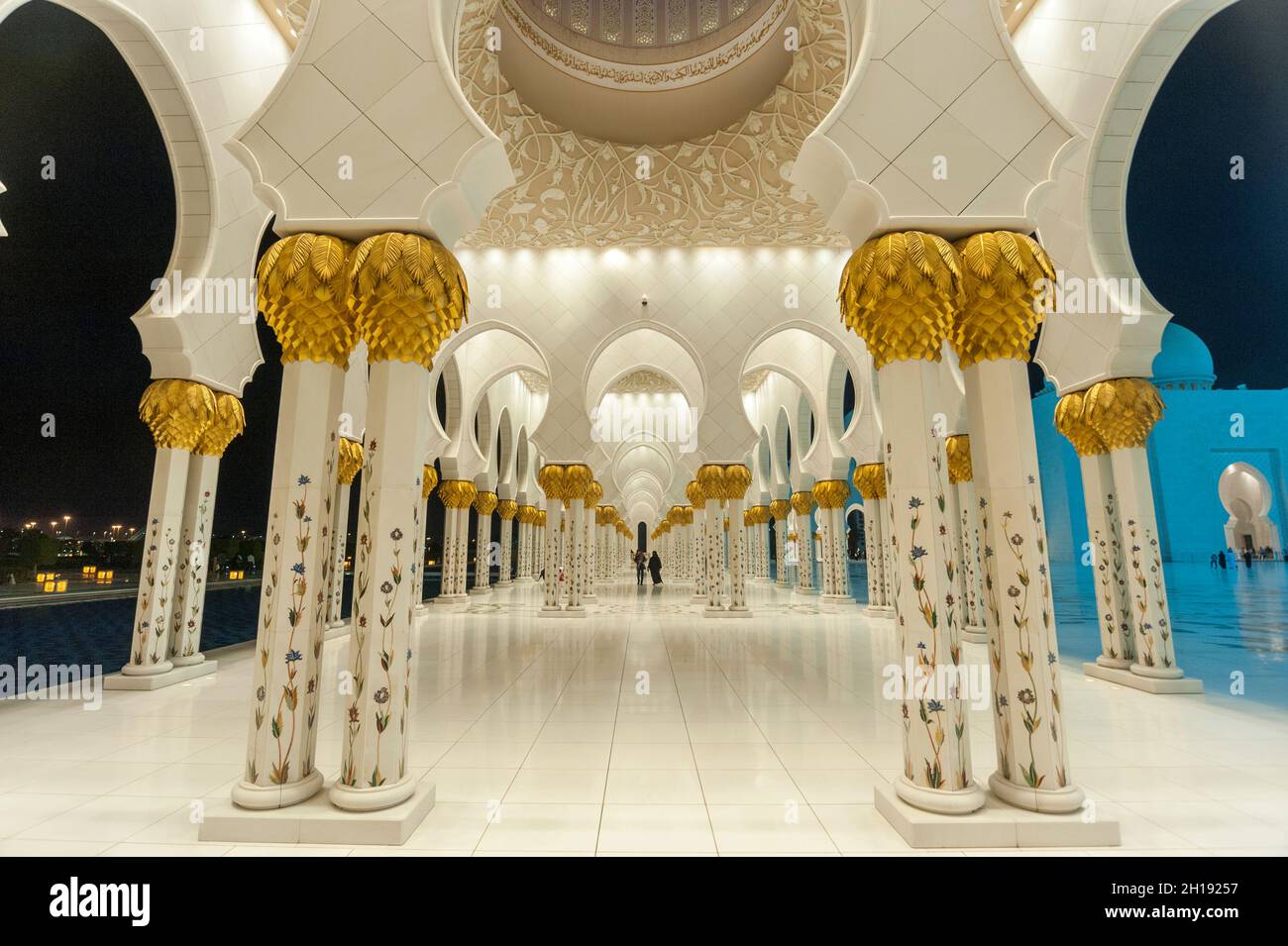 A columned walkway at the Sheikh Zayed Grand Mosque at night. Sheikh ...