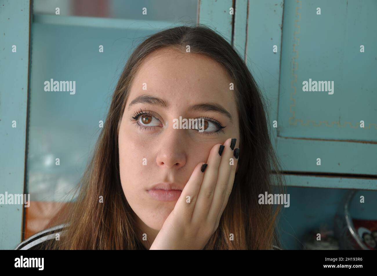 Cute girl with hand on her cheek. Serious pretty girl with hand on the ...