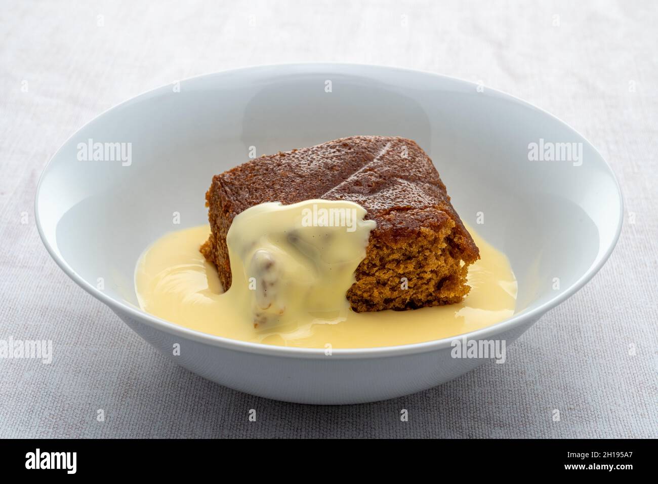 Slice of syrup sponge cake with dairy custard Stock Photo - Alamy