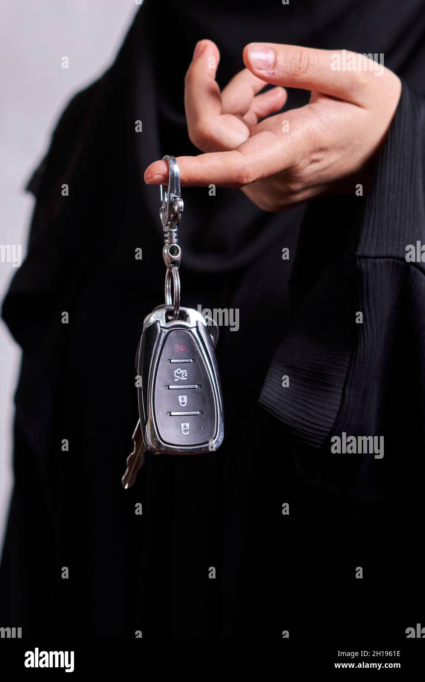 Arabian woman holding car keys. Muslim woman in black traditional ...