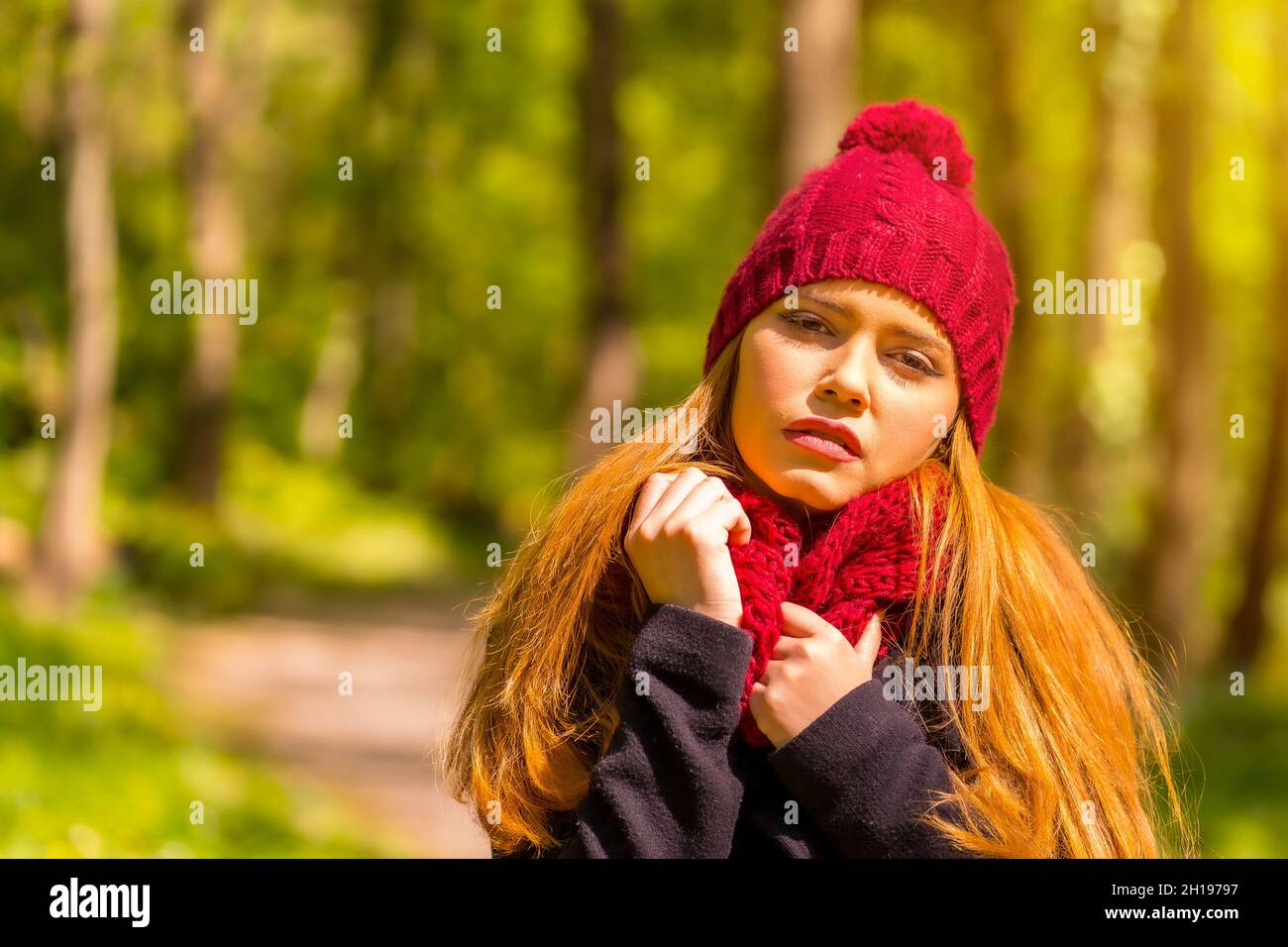 A portrait of a Hispanic, redhead girl with a scarf and red woolen hat ...