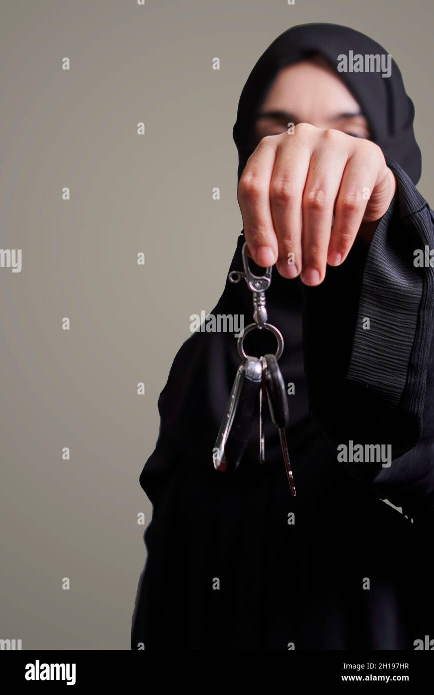 Arabian woman holding car keys. Muslim woman in black traditional ...