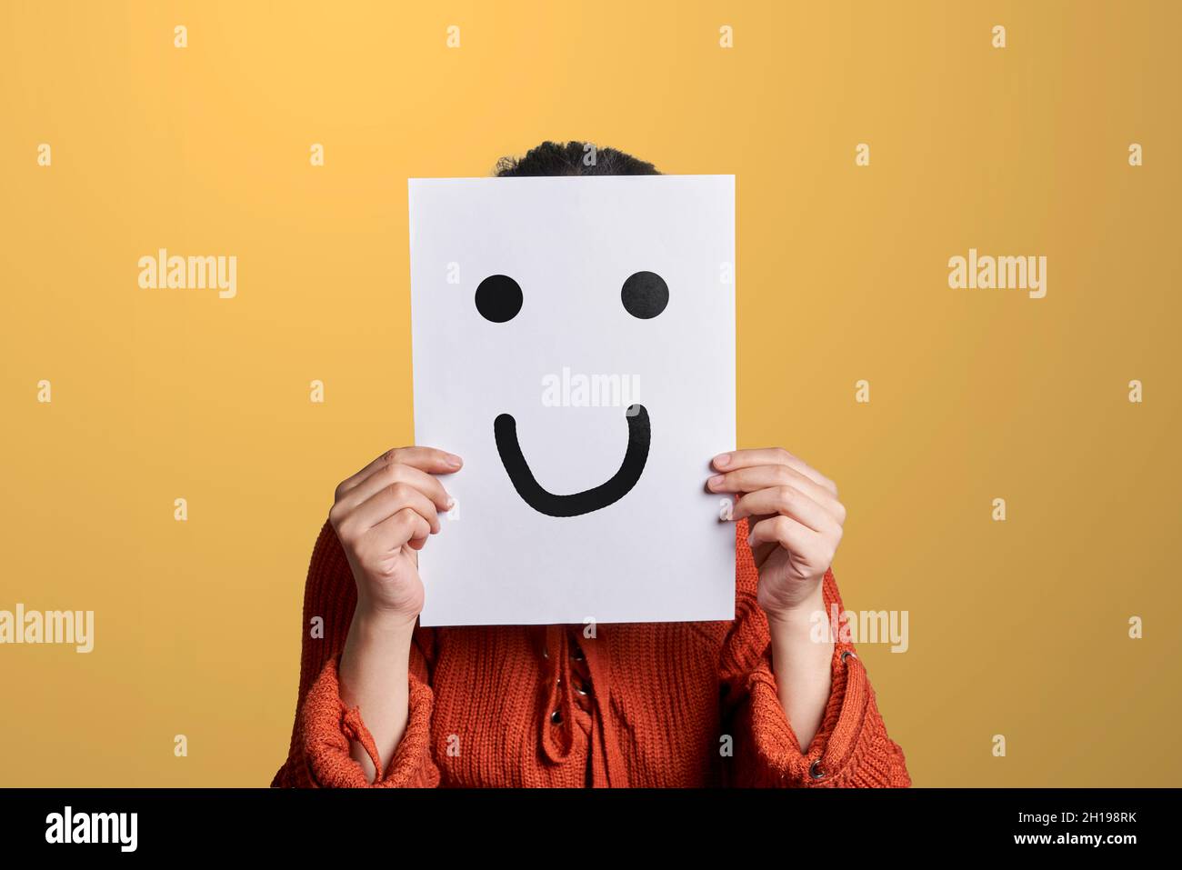 Woman holds a paper with drawn fake smile. Woman hiding her feelings ...