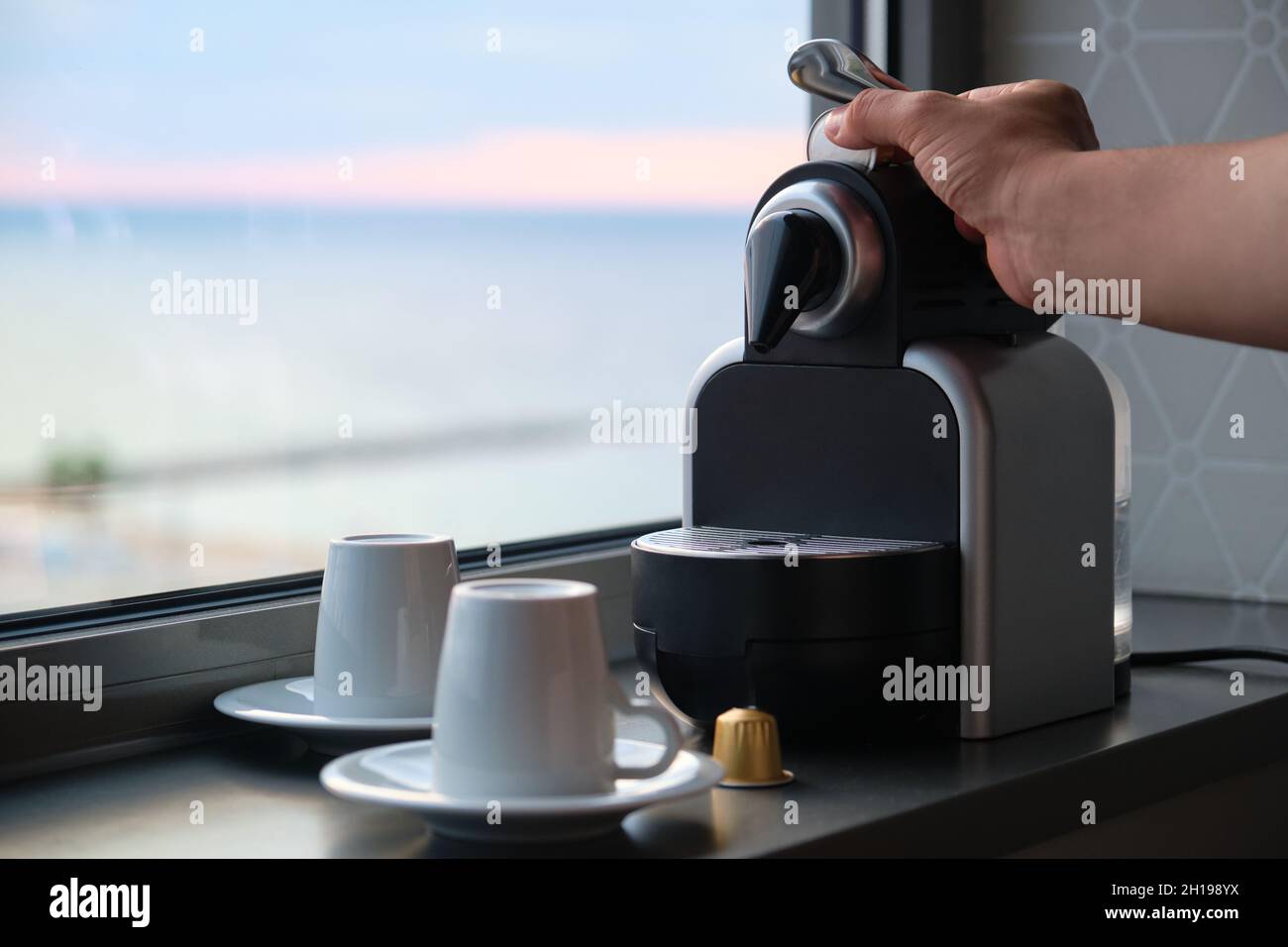 Hand preparing coffee in a coffee machine with capsules Stock Photo - Alamy