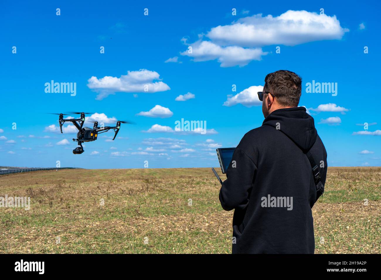 The pilot controls a professional drone for agricultural survey Stock ...