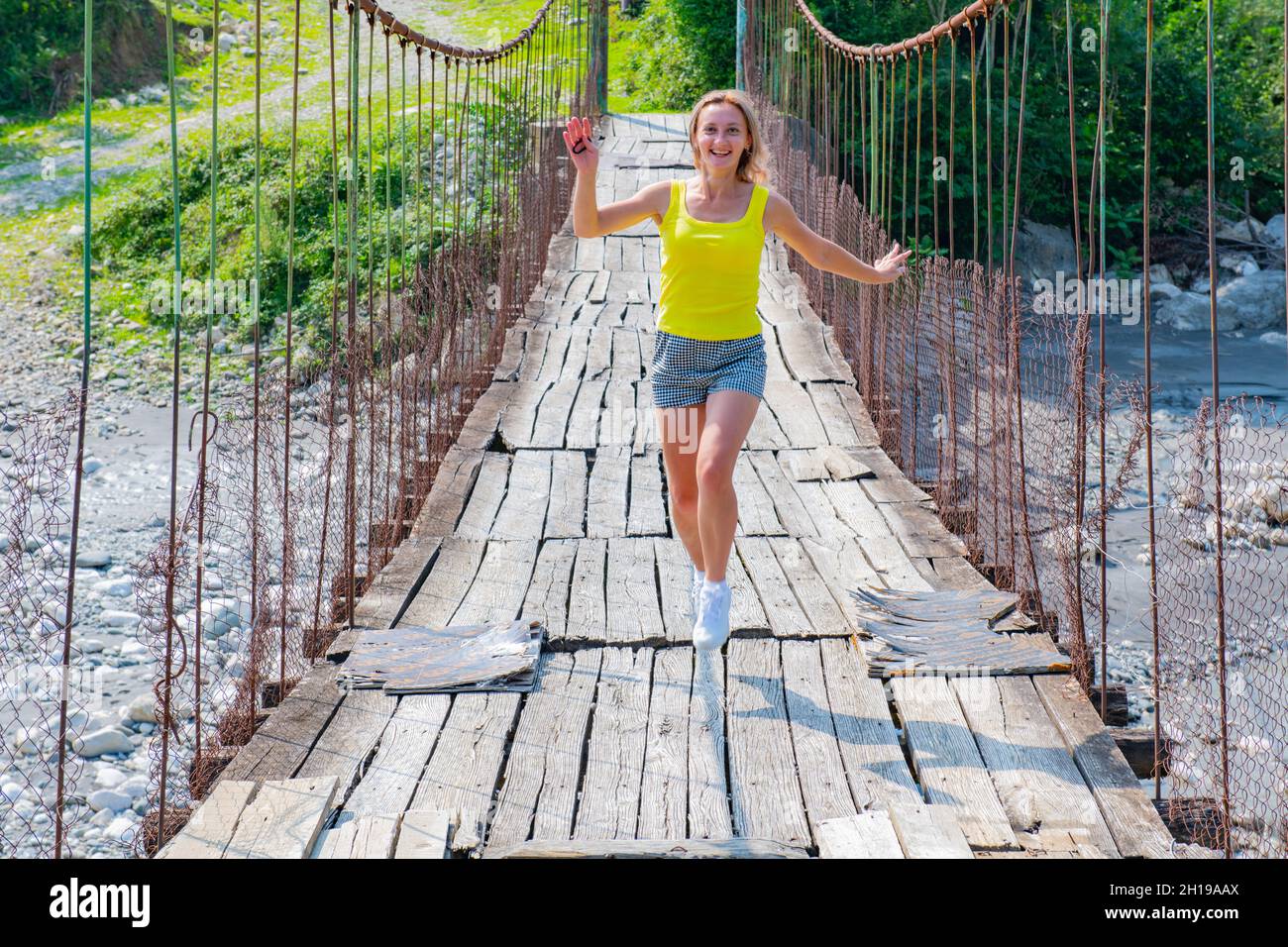 girl jumping on a suspension bridge in Georgia Stock Photo - Alamy
