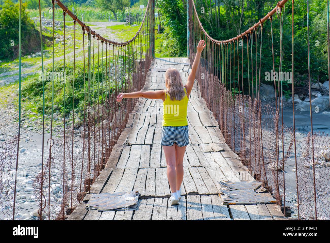 one woman stands on a suspension bridge in Georgia Stock Photo - Alamy