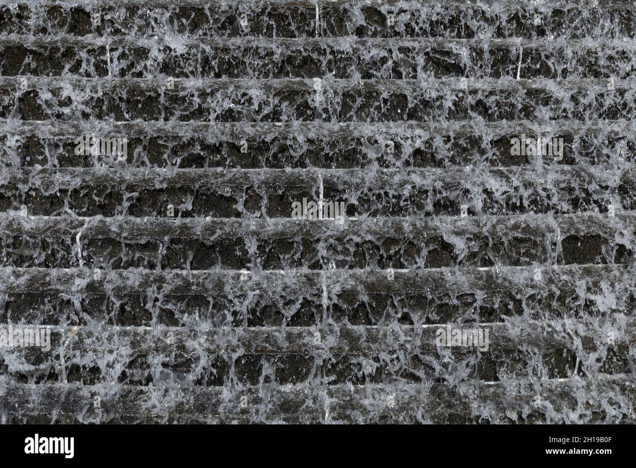 Head on view of water cascading down concrete steps in a public water ...