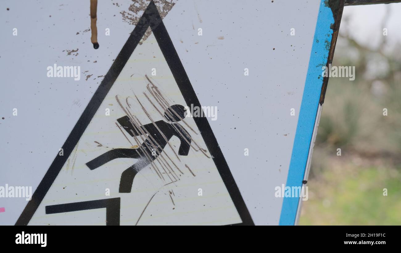 slippery ground sign and it is deformed by hooligans Stock Photo - Alamy