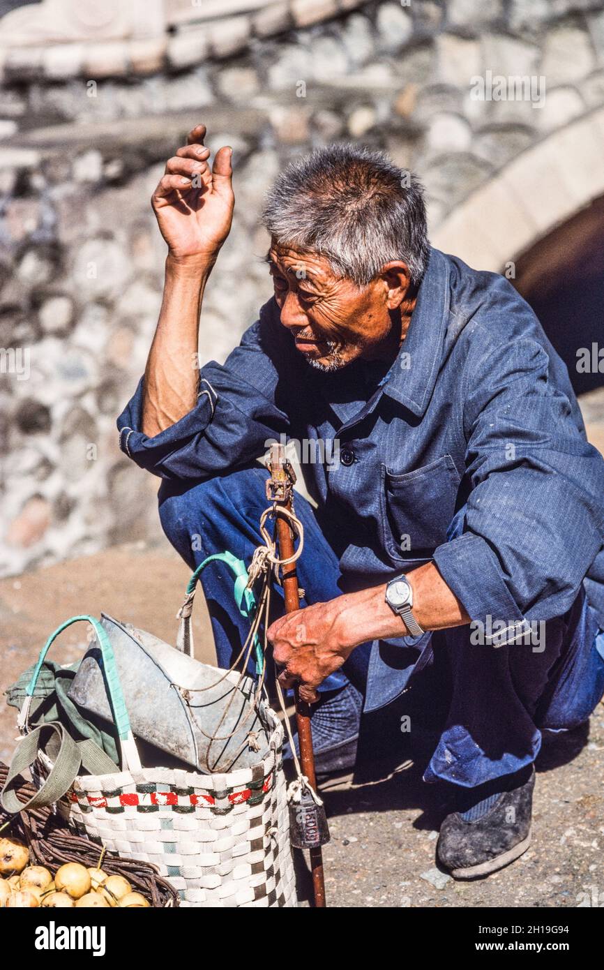 A vendor with his balance scale selling produce in a farmers market in ...