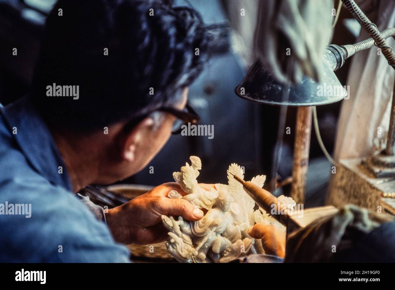 An artisan in a jade factory carves a jade figurine. Beijing, China ...