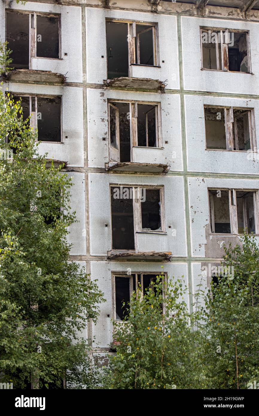 A damaged abandoned panel house with decorative facade of small white ...