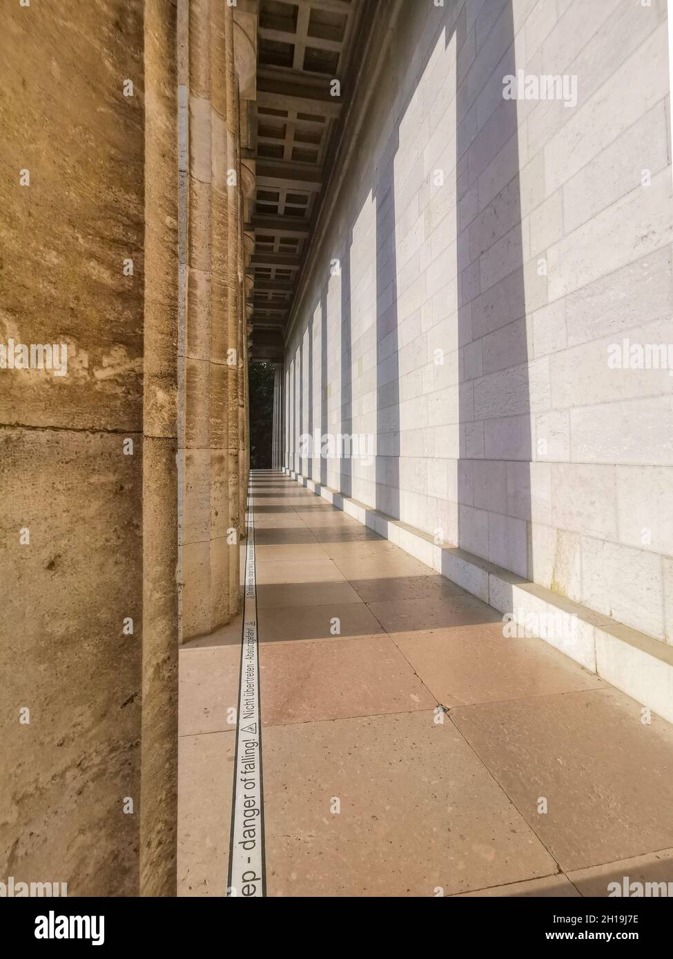 A vertical shot of the line of columns of a building and the shadow on ...