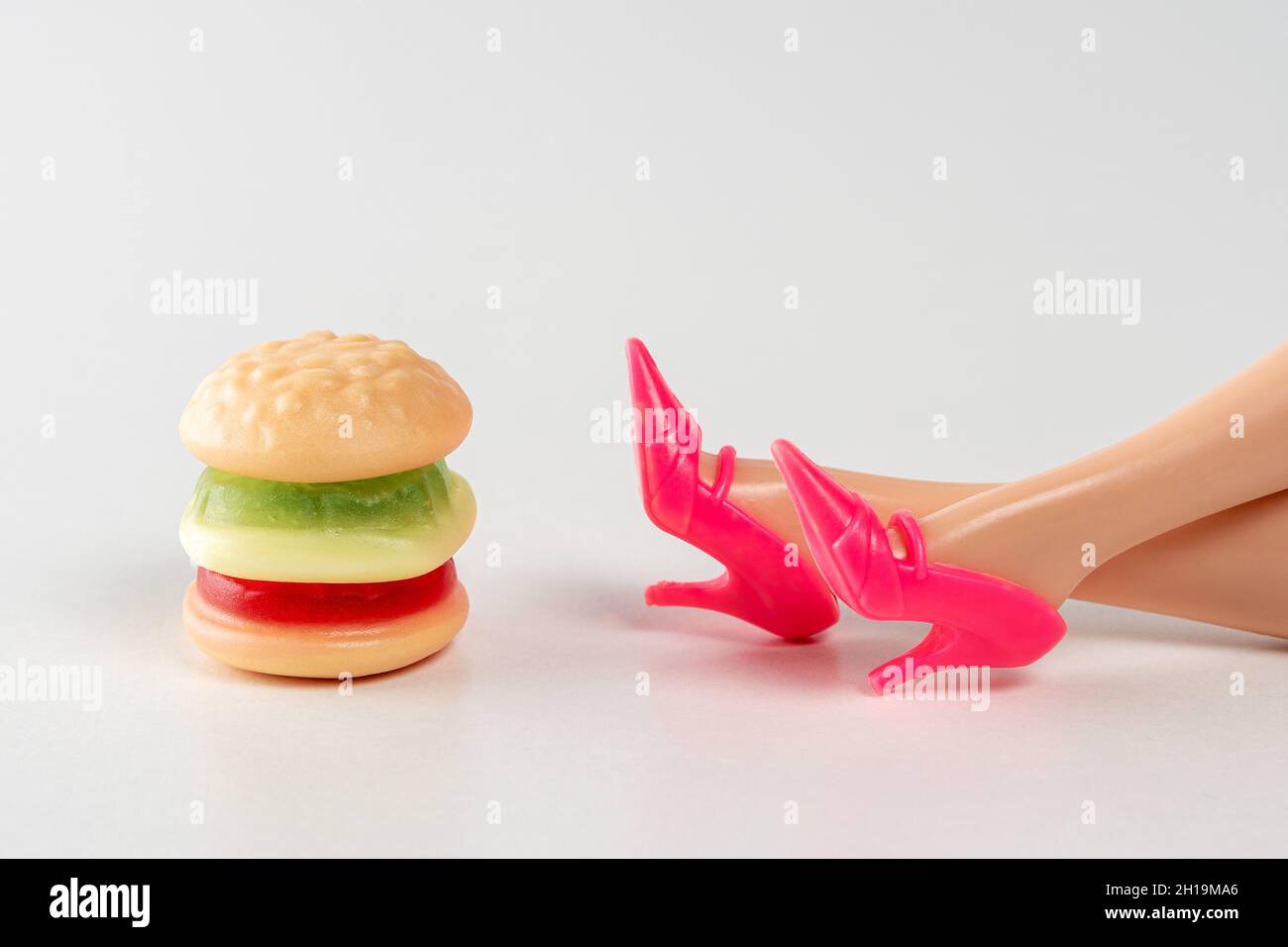 Colorful candy hamburger with a legs of doll. Minimal fitness food ...