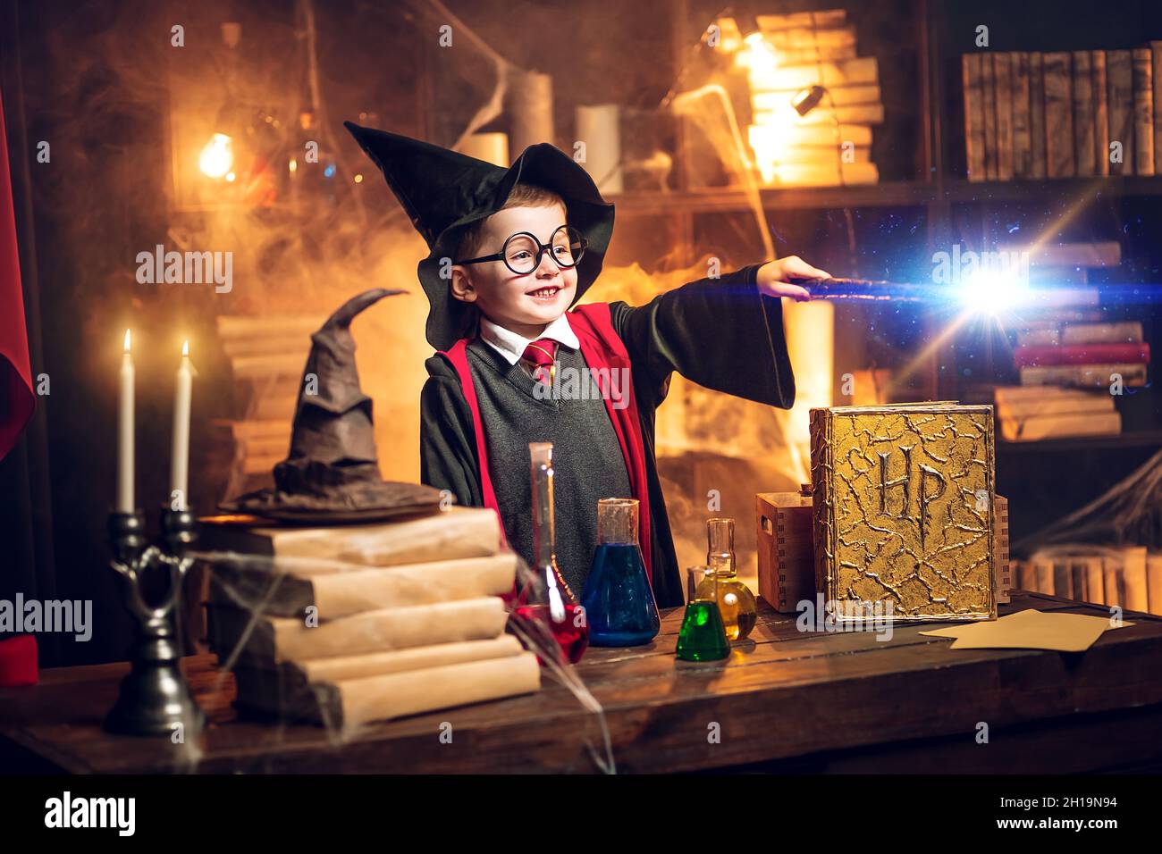 Small wizard in glasses, wizard's hat holds magic wand. Cosplay ...