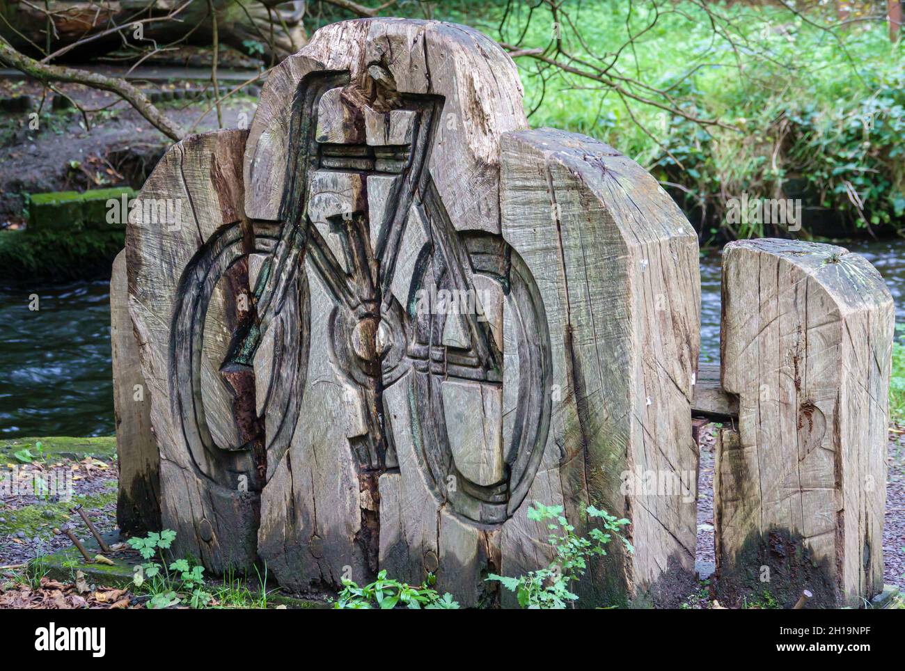 a wooden bench carved out of a tree trunk with a bicycle carved in to ...