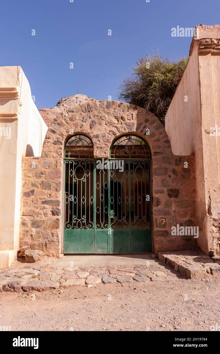 A vertical view of green gates of an old building under the blue sky ...