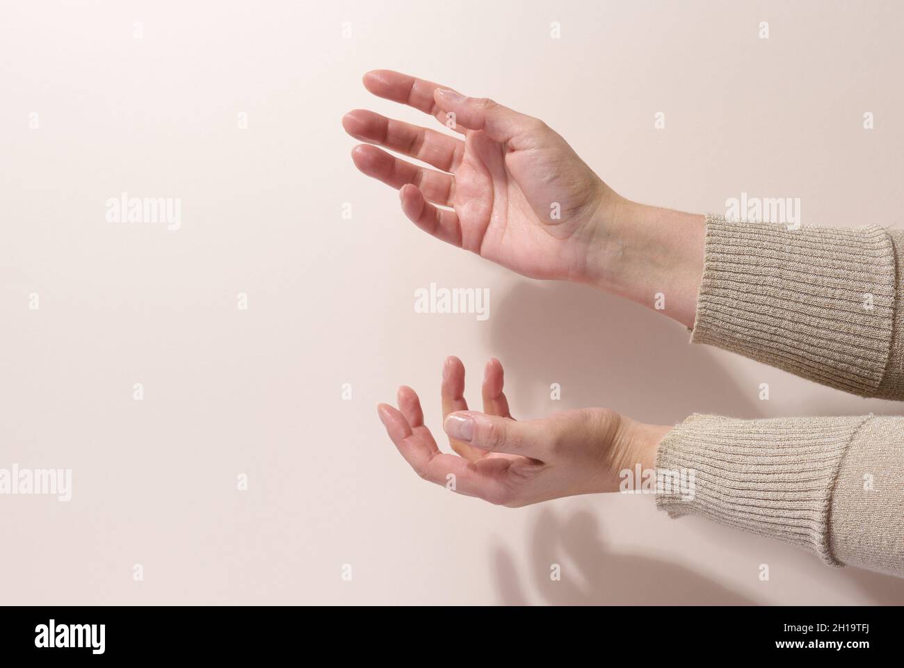two female hands hold any object on a beige background. Product ...