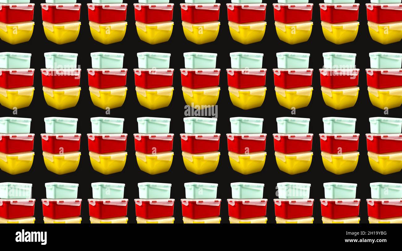 Yellow, mint and red plastic lunch boxes on a black background. Pattern ...