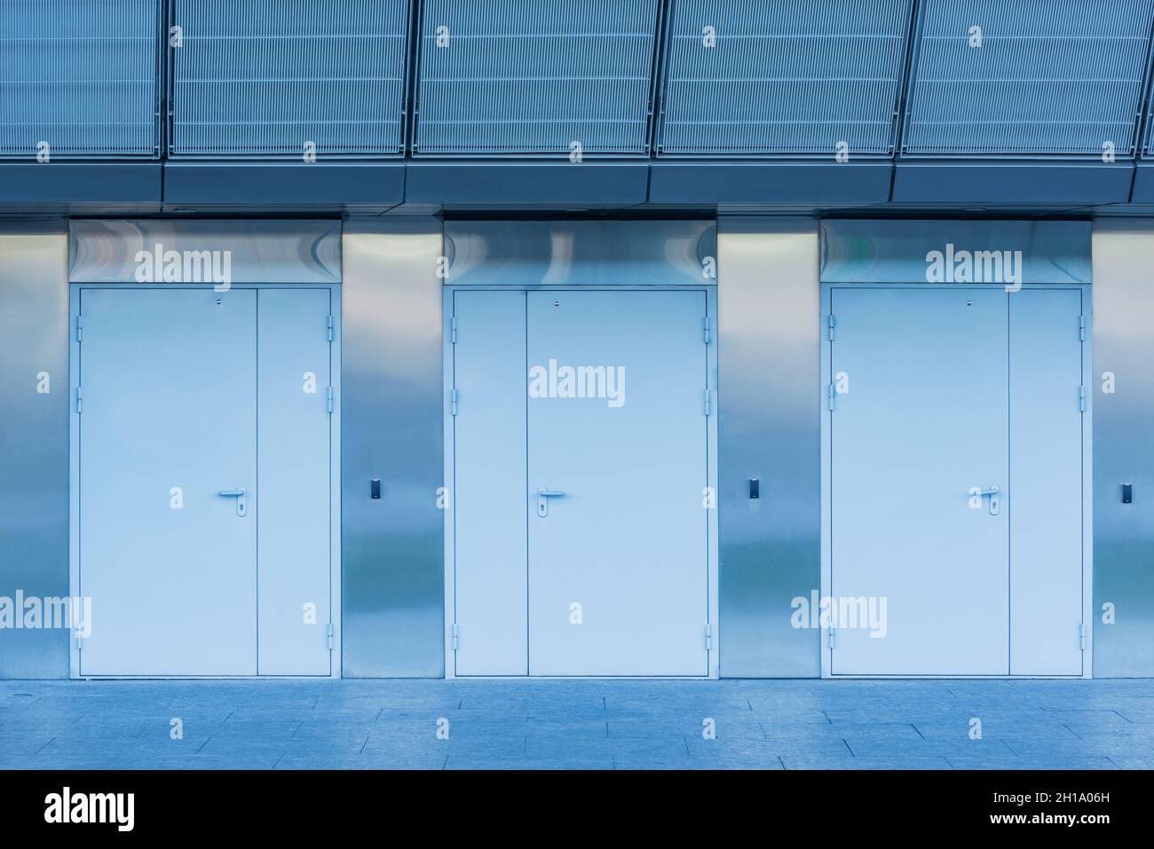 Three closed doors of the new industrial building Stock Photo - Alamy