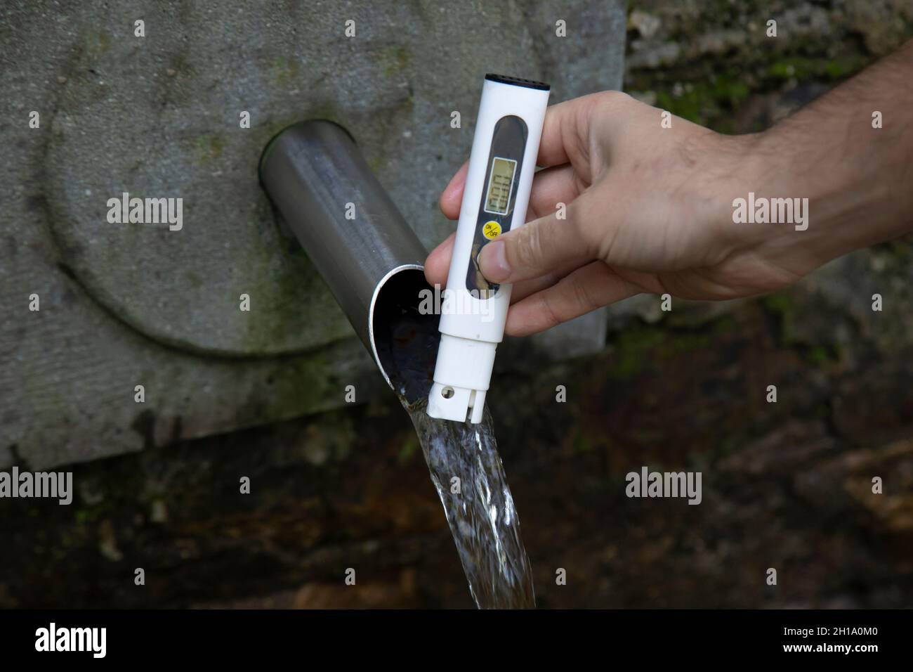 man measures the water quality of a natural spring with tester Stock ...