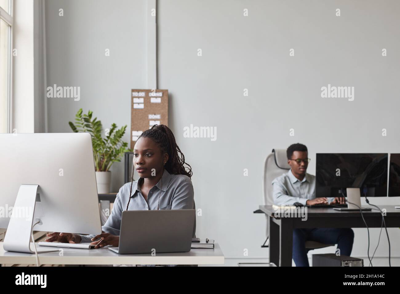 Wide angle portrait of two African-American young people using ...