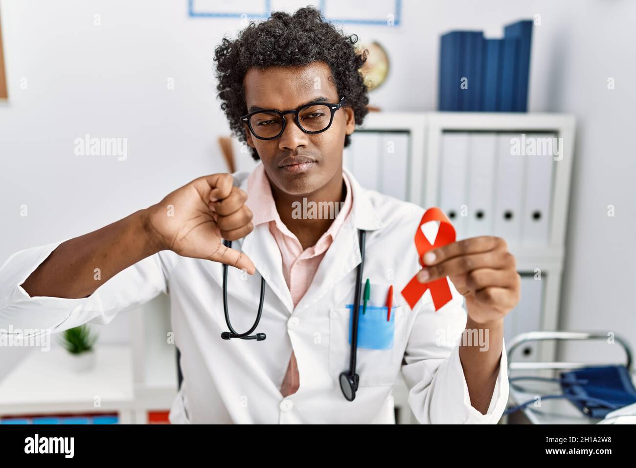 African doctor man holding support red ribbon with angry face, negative ...