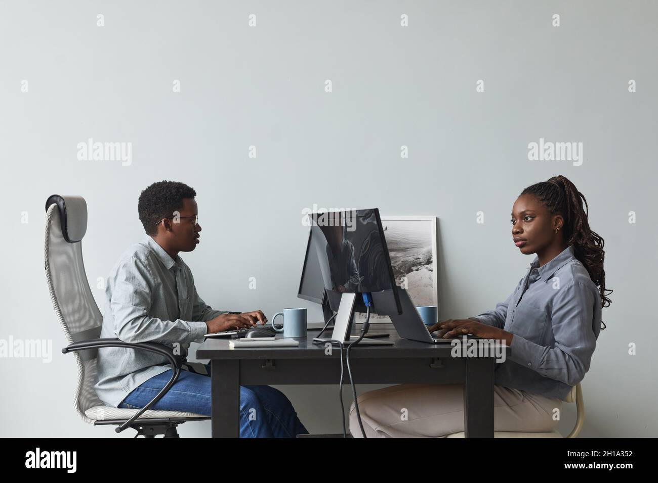 Minimal side view portrait of two African-American young people using ...