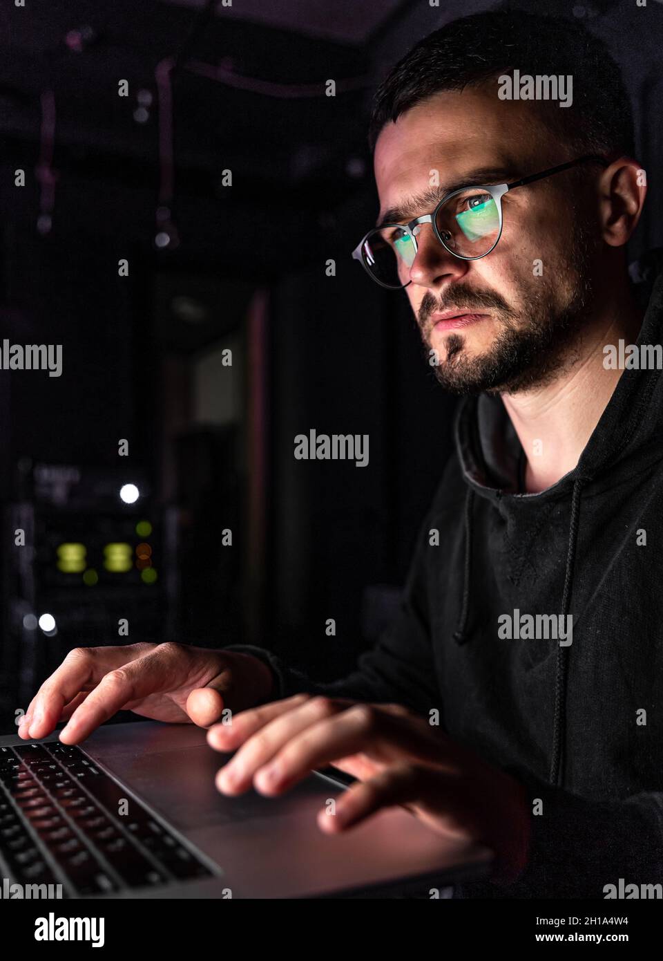 A man with glasses works at a computer late at night Stock Photo - Alamy