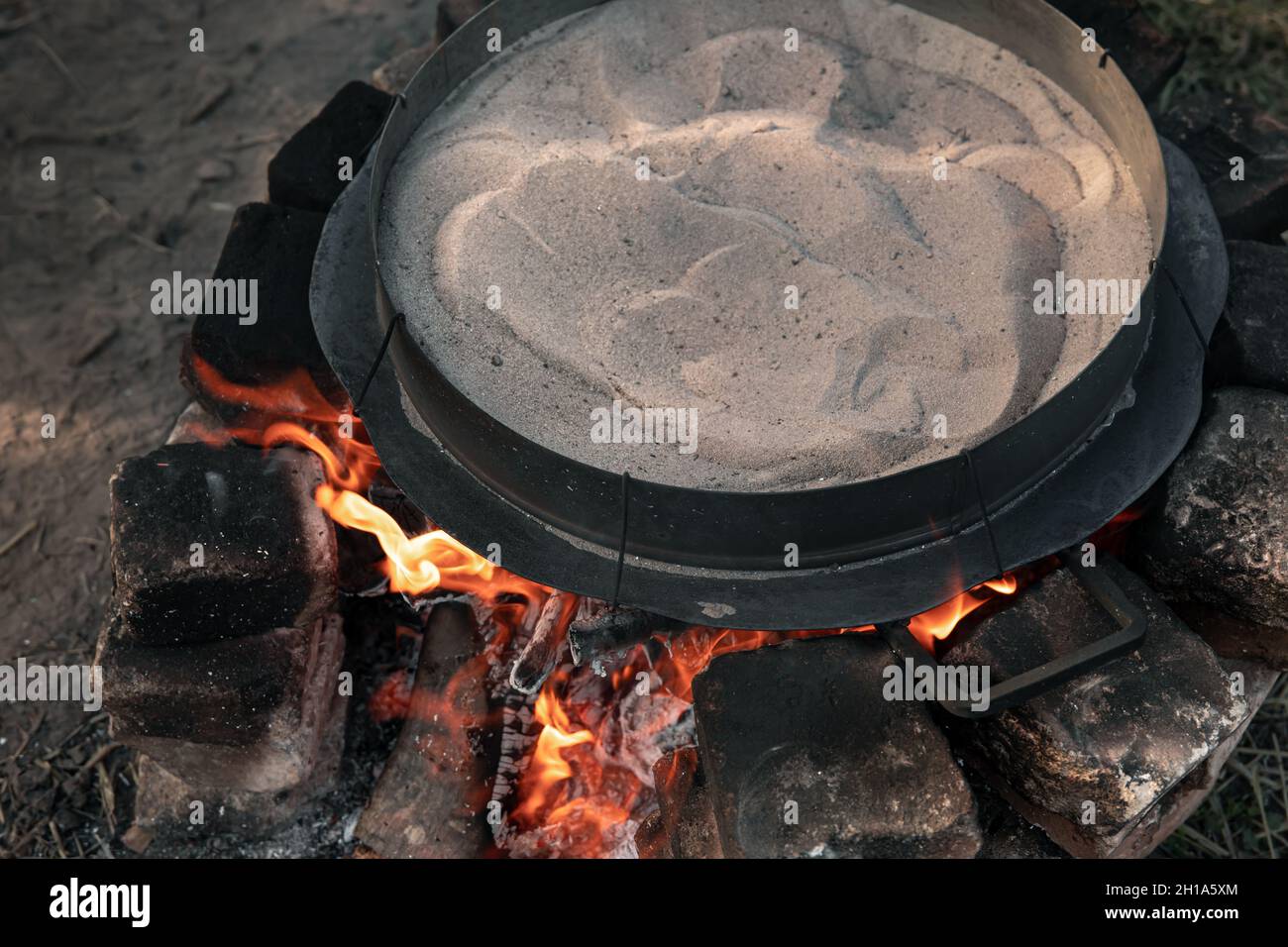 The sand is heated on the fire to make coffee Stock Photo - Alamy