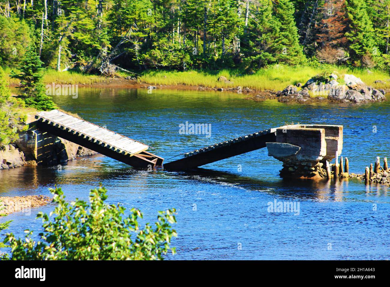 An old bridge split in the middle and collapsed into a river, Trinity ...