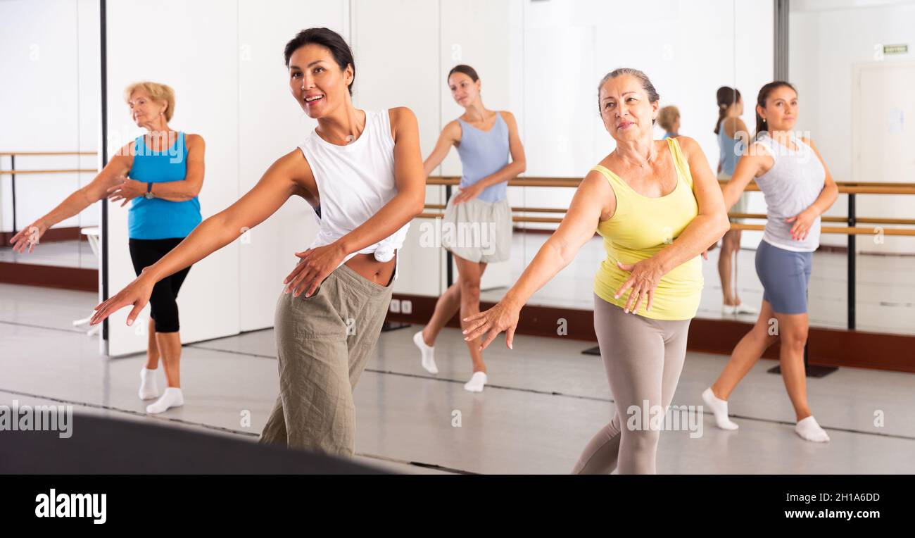 Positive women of different ages dancing strip plastic in dance class ...