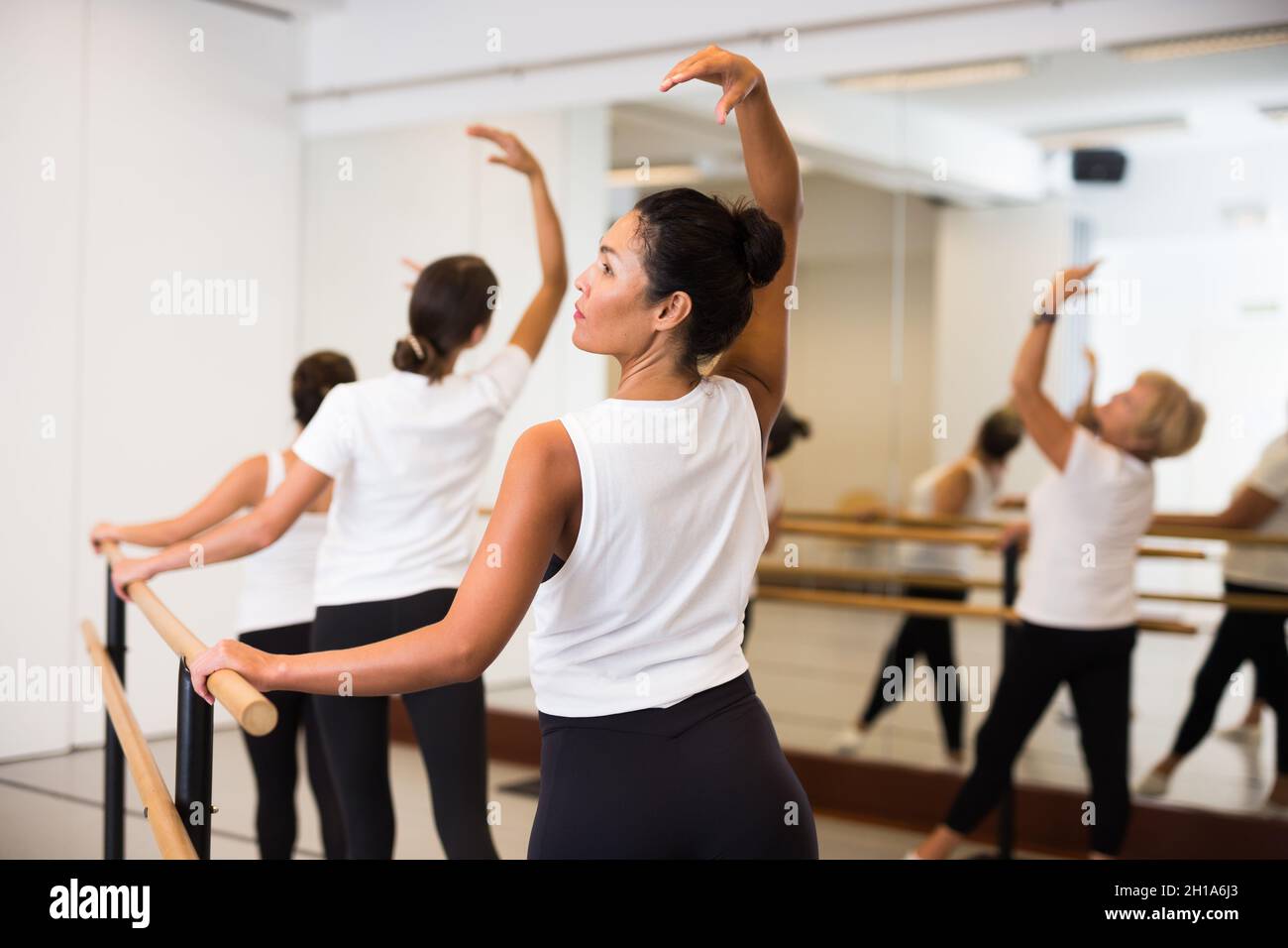 Group of women engaged in ballet in a dance studio performs a ...